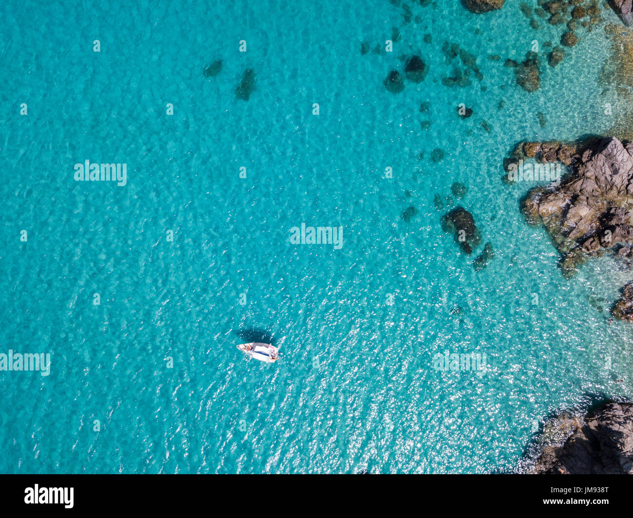 Aerial view of a moored boat floating on a transparent sea. Diving ...