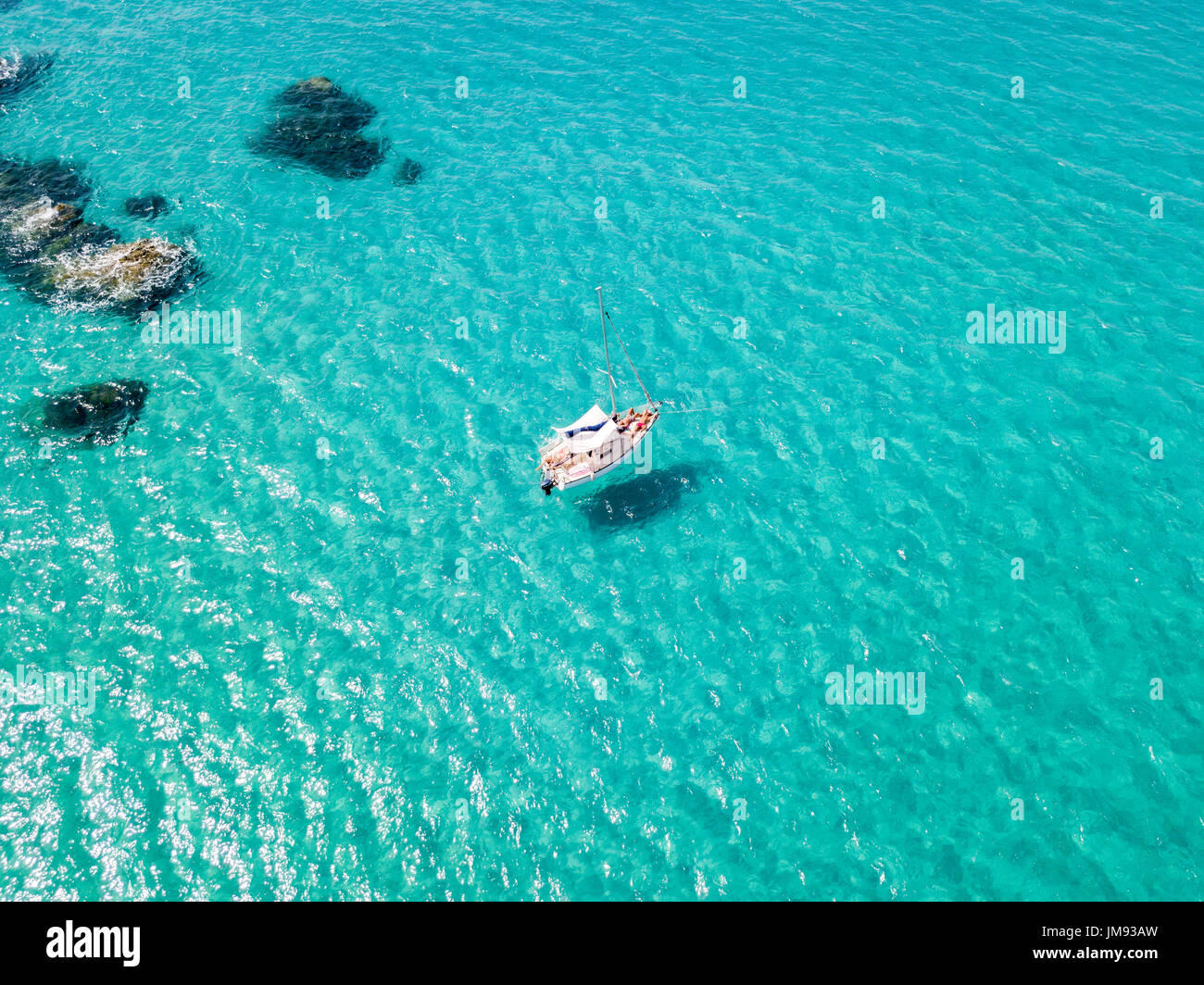 Aerial view of a moored boat floating on a transparent sea. Diving ...