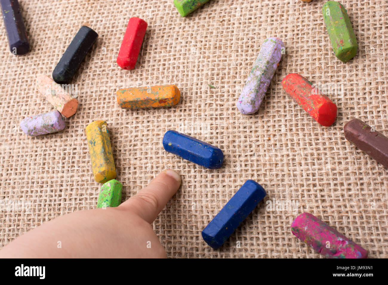 Used color crayons and a toddlers hand pointing Stock Photo - Alamy