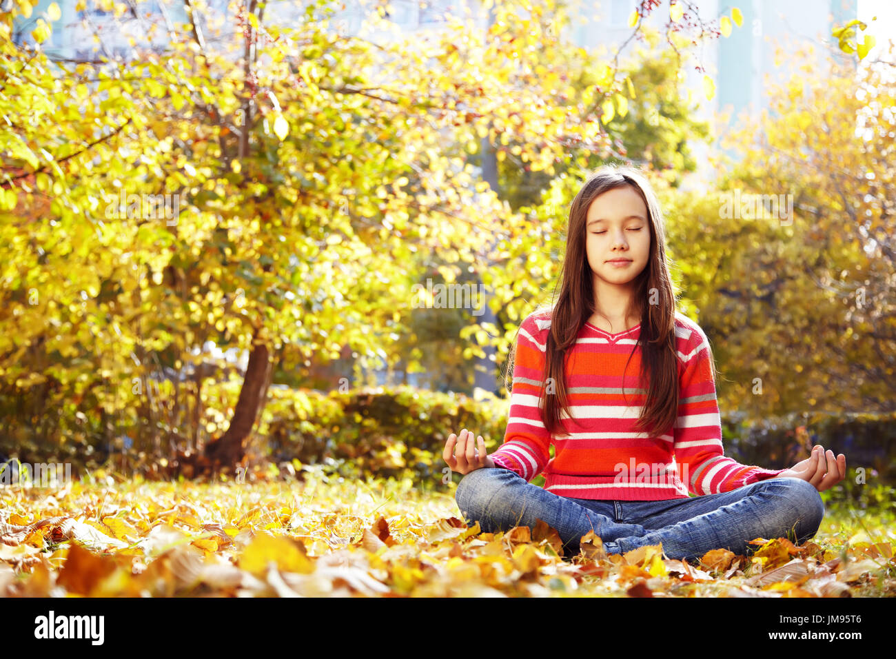 teenage girl meditating in the autumn park Stock Photo - Alamy