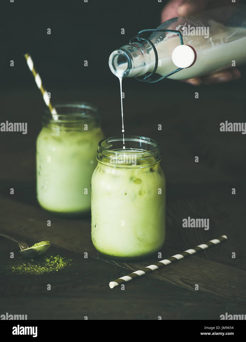 Refreshing iced coconut matcha latte and hand pouring milk Stock Photo ...