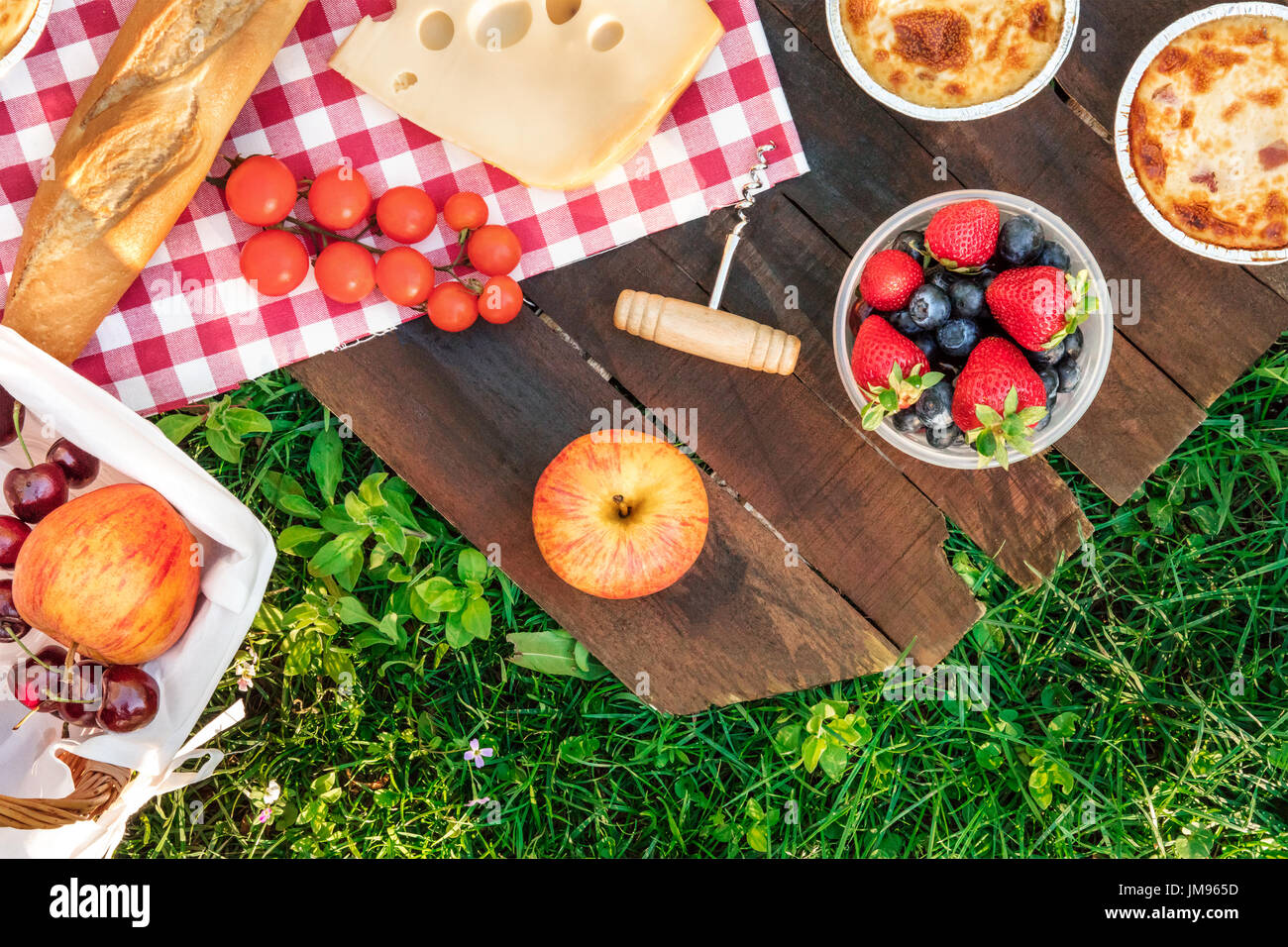 Overhead photo of picnic with apples, fresh fruit in plastic container ...