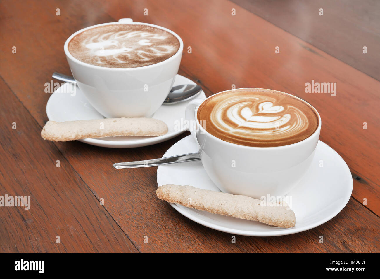 two cups of latte art coffee in a white cup on wooden background Stock ...