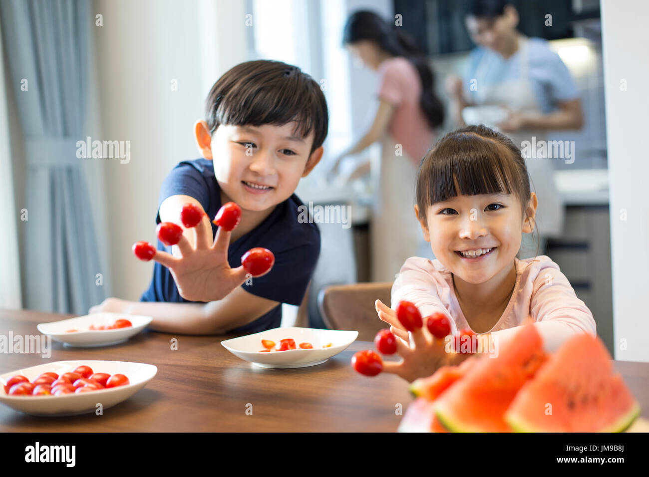 Happy Chinese siblings and cherry tomatoes Stock Photo - Alamy