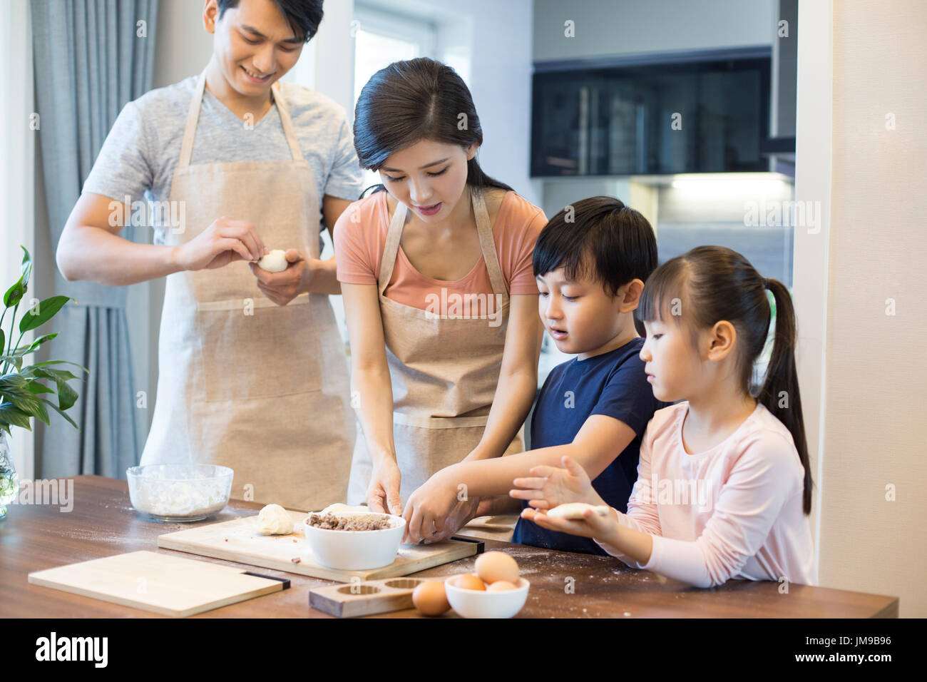 Happy young Chinese family baking together Stock Photo - Alamy