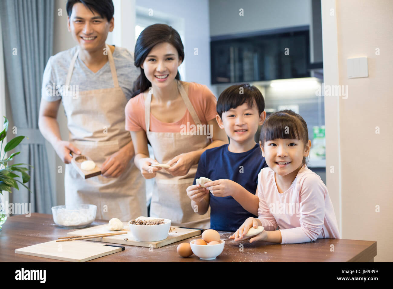 Happy young Chinese family baking together Stock Photo - Alamy