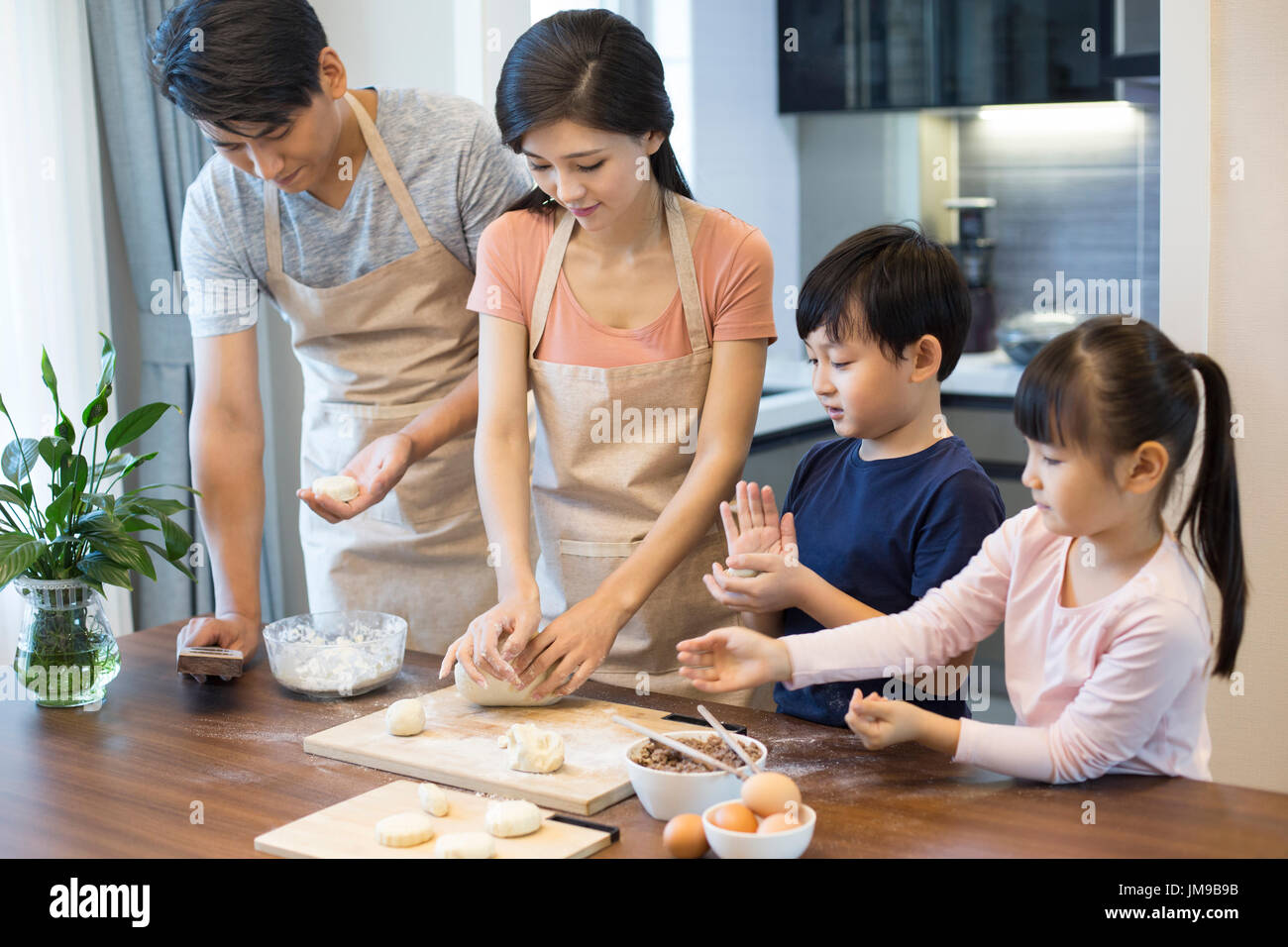 Happy young Chinese family baking together Stock Photo - Alamy