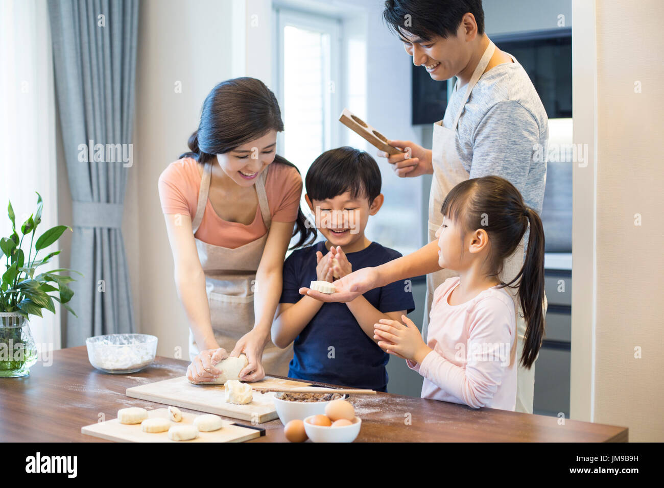 Happy young Chinese family baking together Stock Photo - Alamy