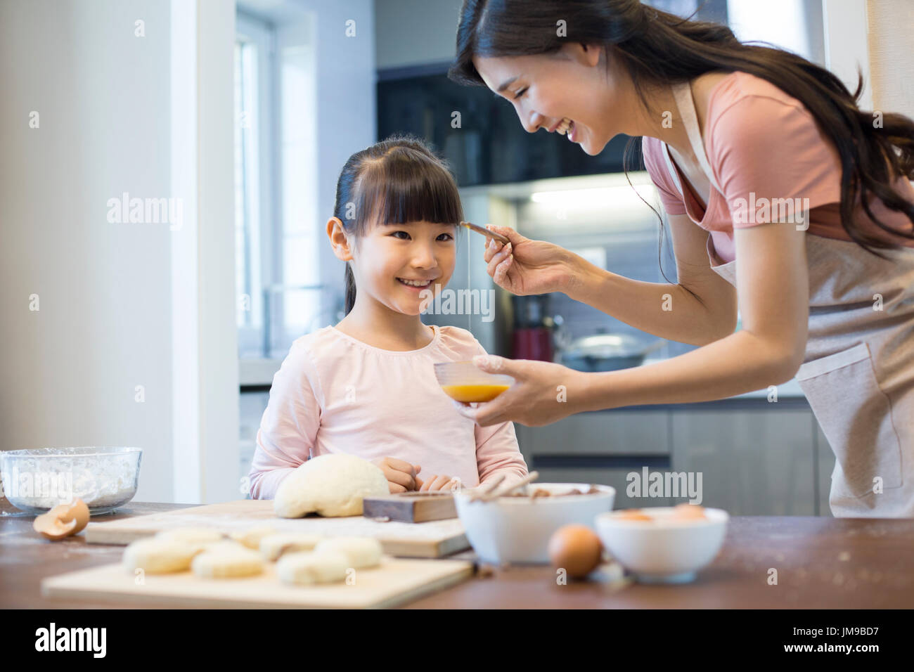 Happy young Chinese mother and daughter baking together Stock Photo - Alamy