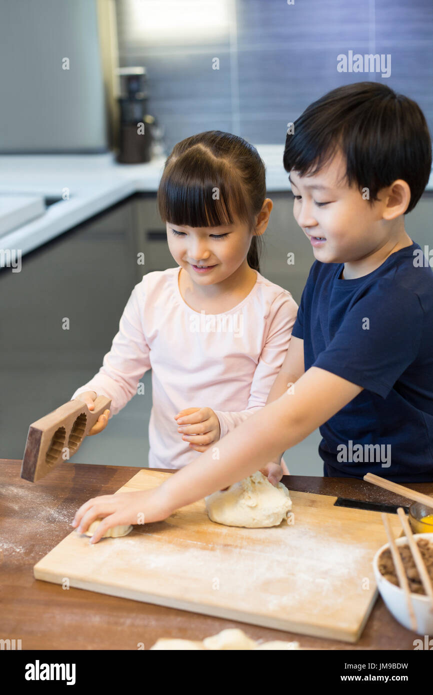 Happy Chinese siblings baking together Stock Photo - Alamy