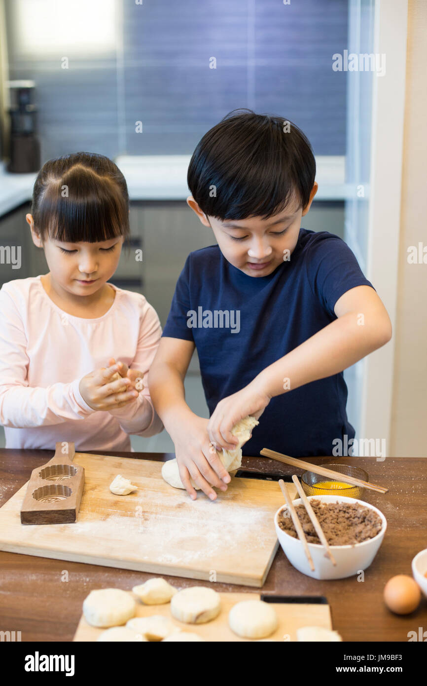Happy Chinese siblings baking together Stock Photo - Alamy