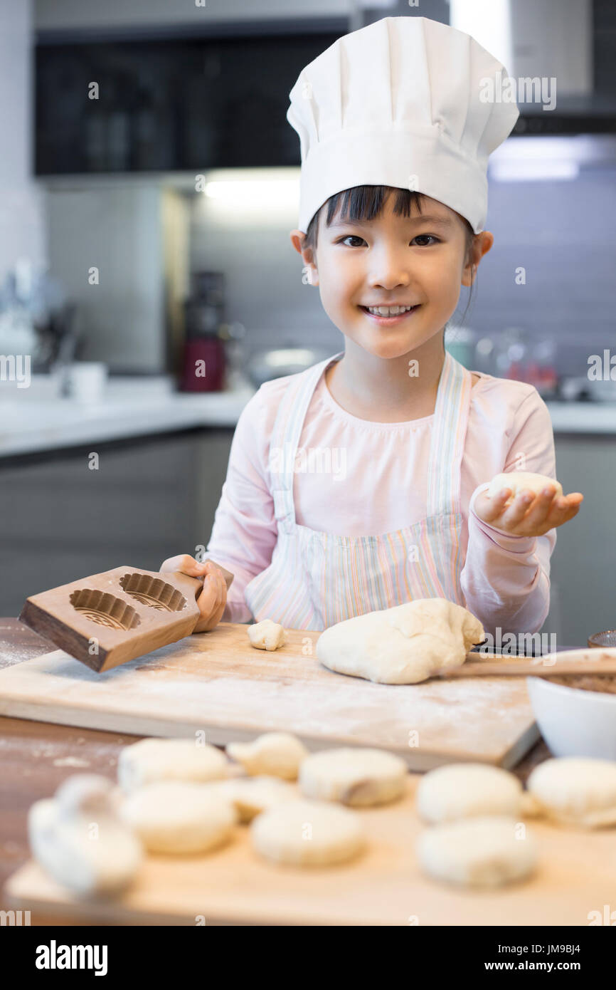 Happy little Chinese girl baking at home Stock Photo - Alamy