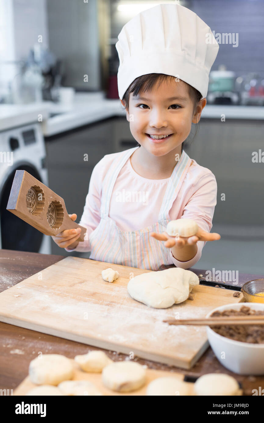 Happy little Chinese girl baking at home Stock Photo - Alamy