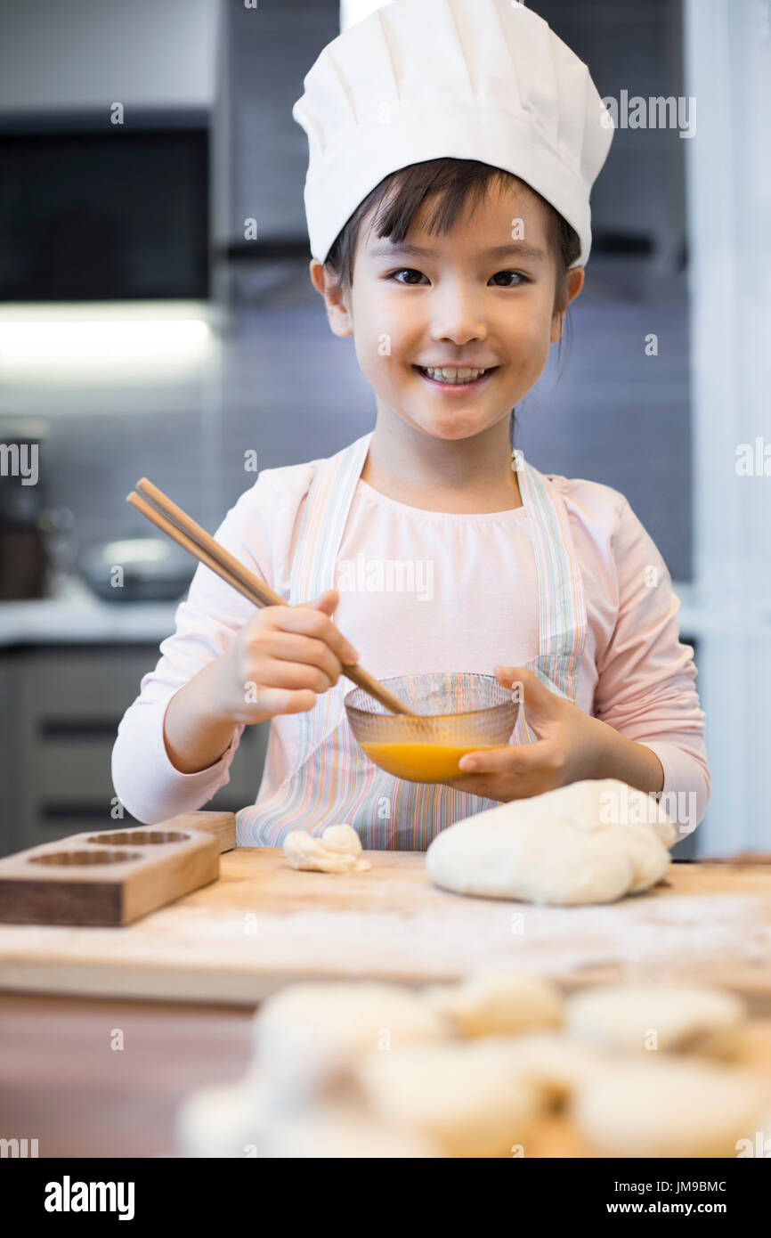Happy little Chinese girl baking at home Stock Photo - Alamy
