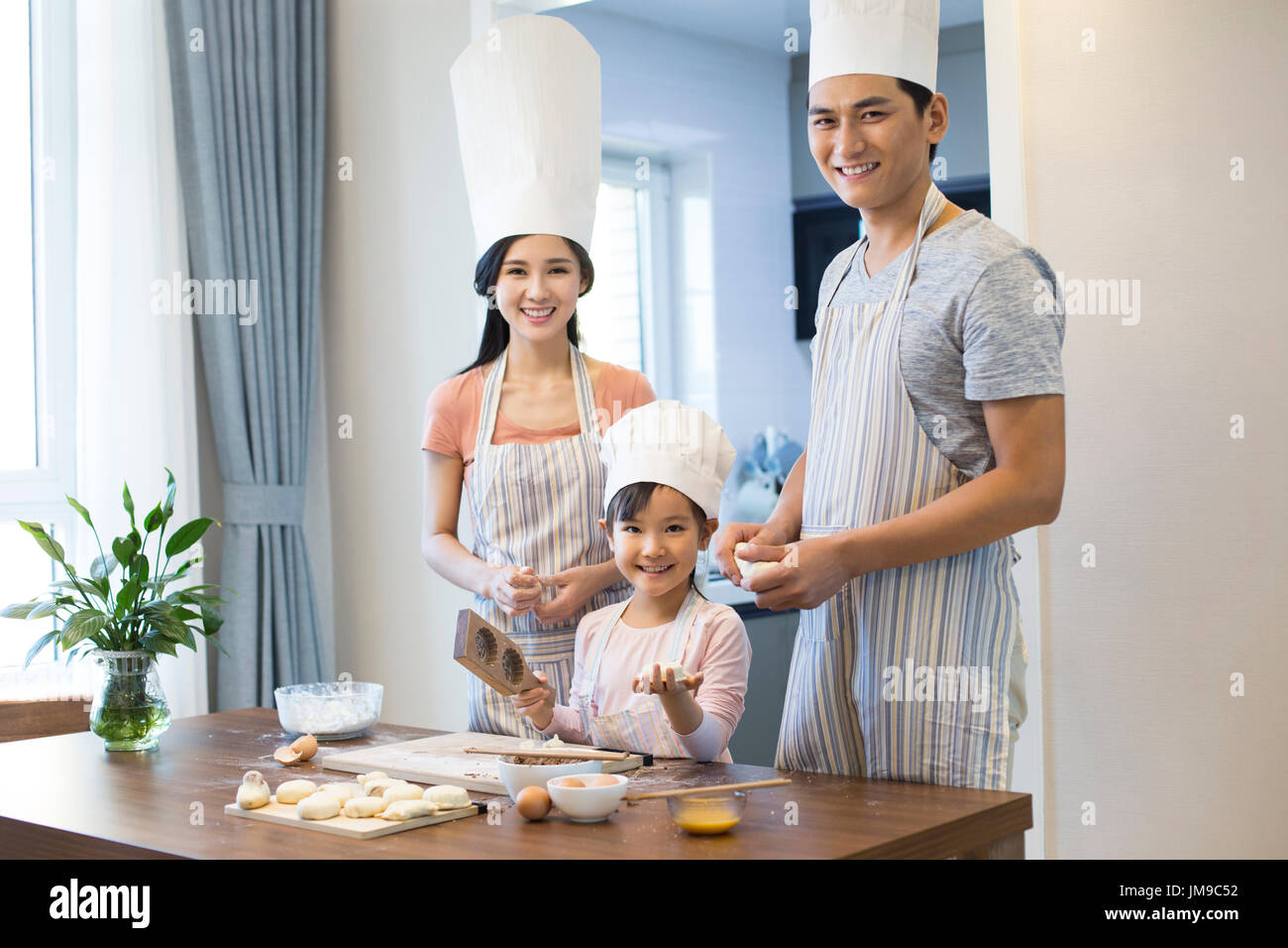 Happy young Chinese family baking together Stock Photo - Alamy