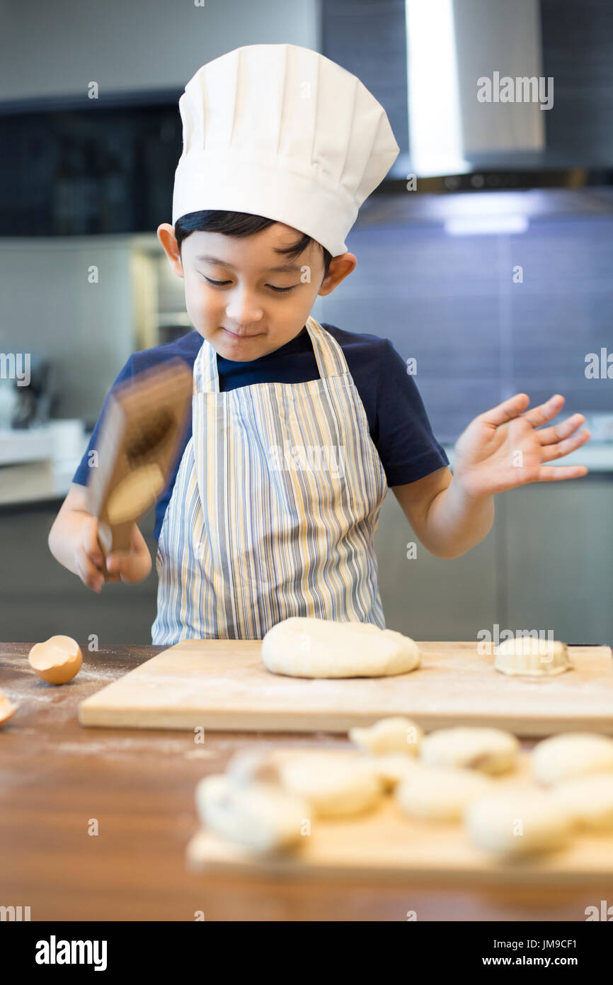 Happy little Chinese boy baking at home Stock Photo - Alamy