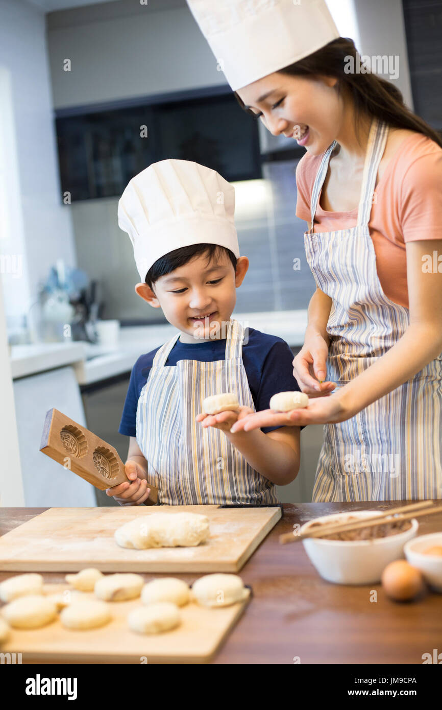 Happy young Chinese mother and son baking together Stock Photo - Alamy