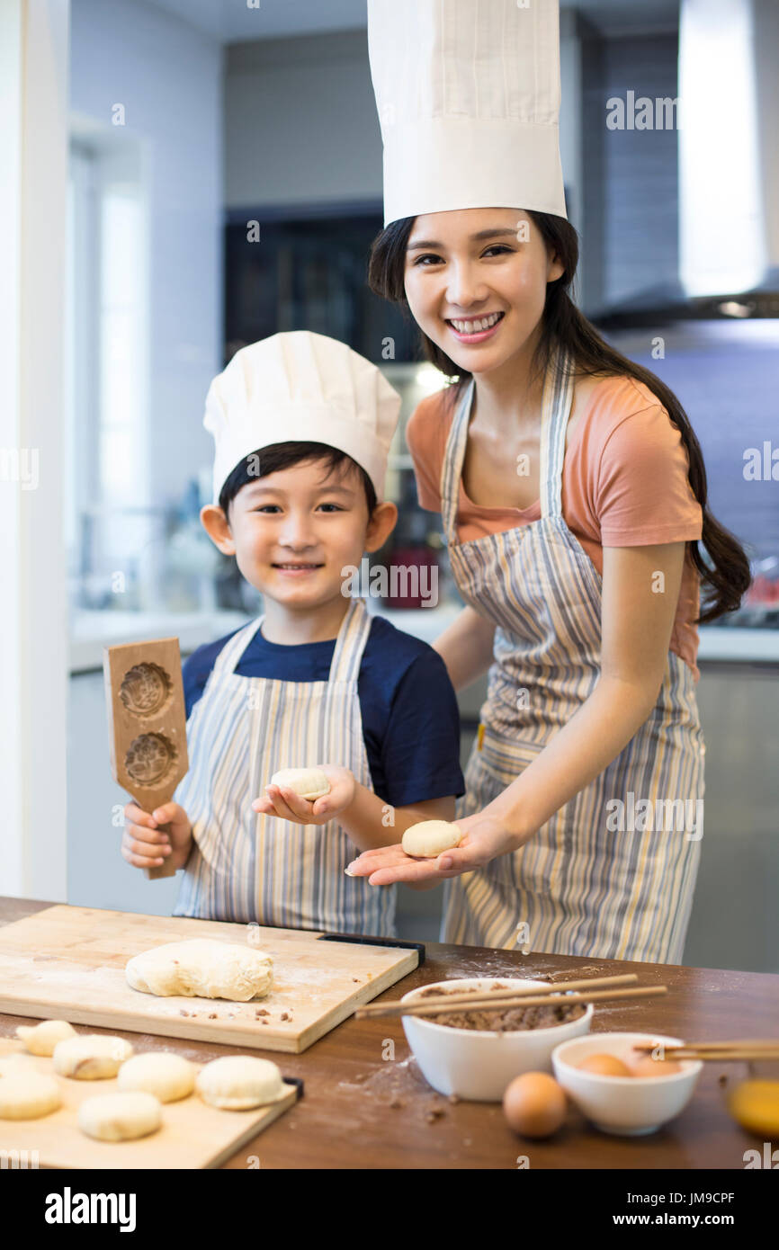 Happy young Chinese mother and son baking together Stock Photo - Alamy