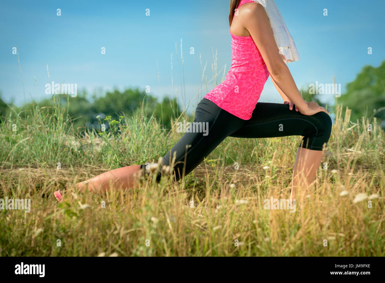 Attractive female stretching before jogging Stock Photo - Alamy