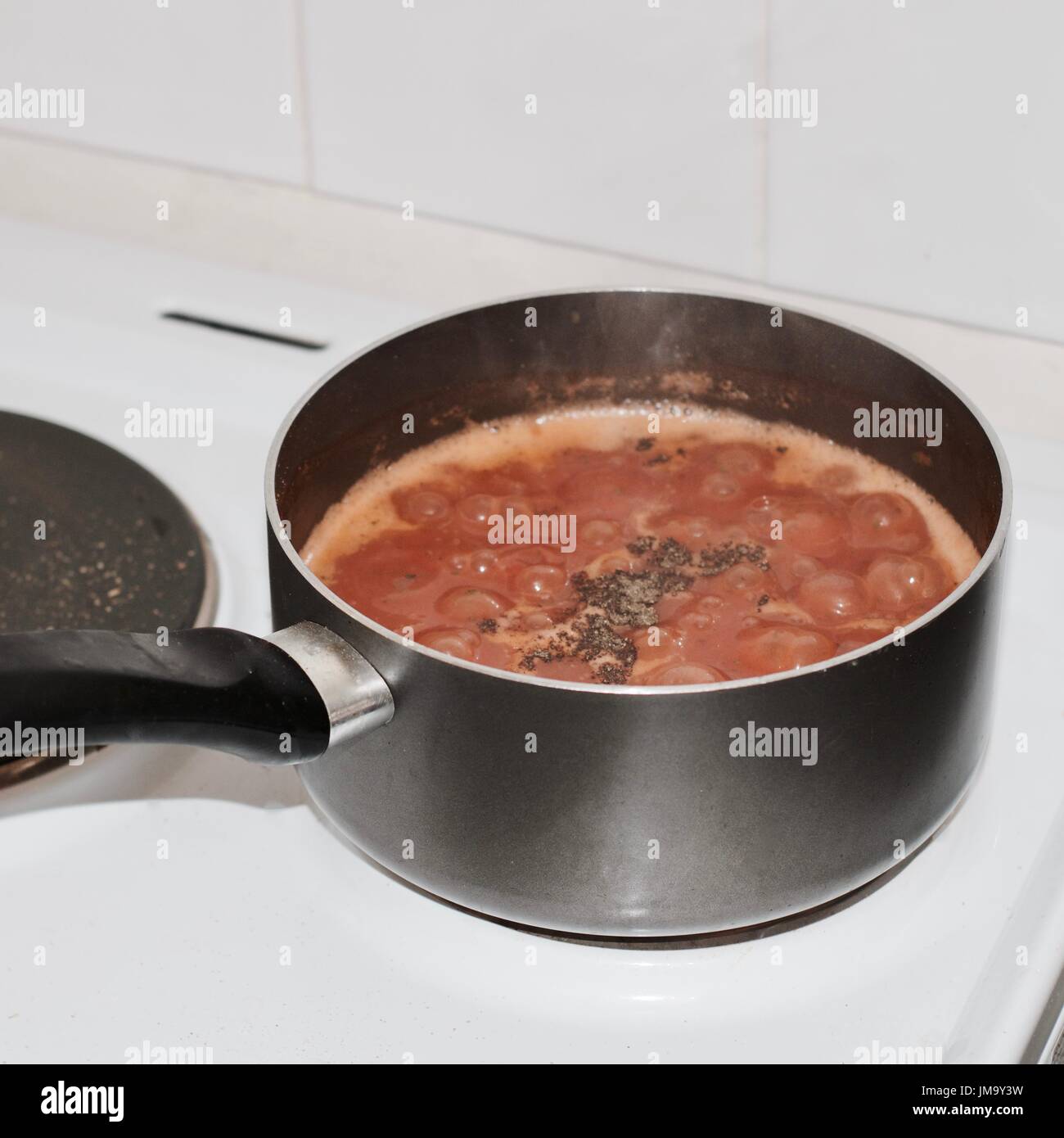 Cooking delicious tomato pasta in pot. Boiling red sauce in the kitchen ...
