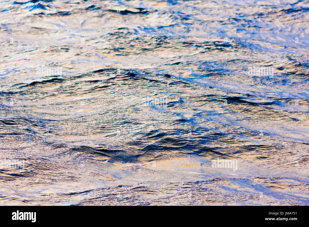 rough Atlantic Ocean, seen from ferry to orkney island, low orange sun ...