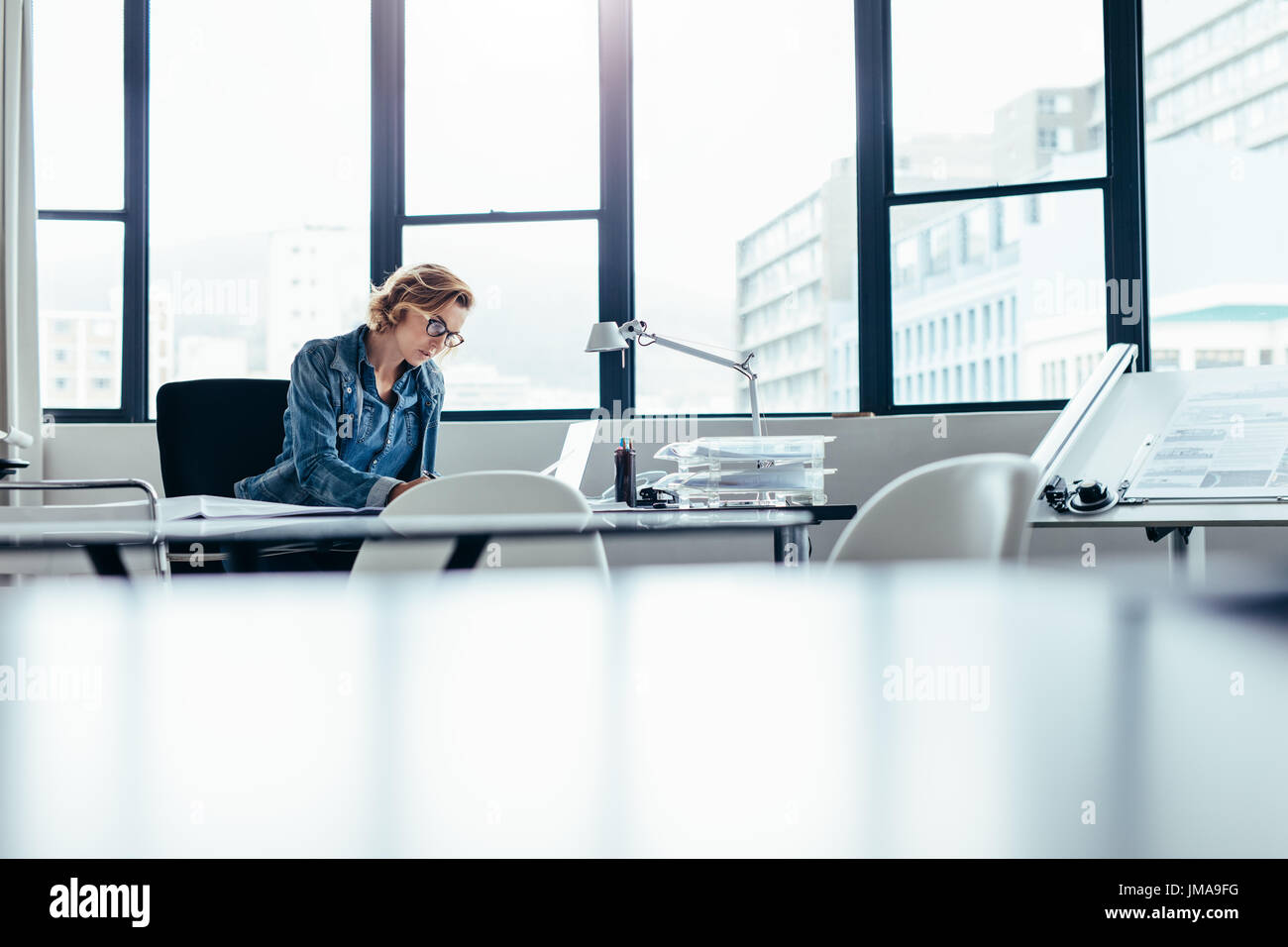 Female manager sitting at her desk and working on laptop. Beautiful ...