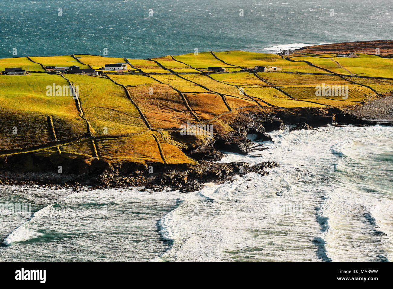 Irish beach during sunset in the summer with a blue sky and waves ...
