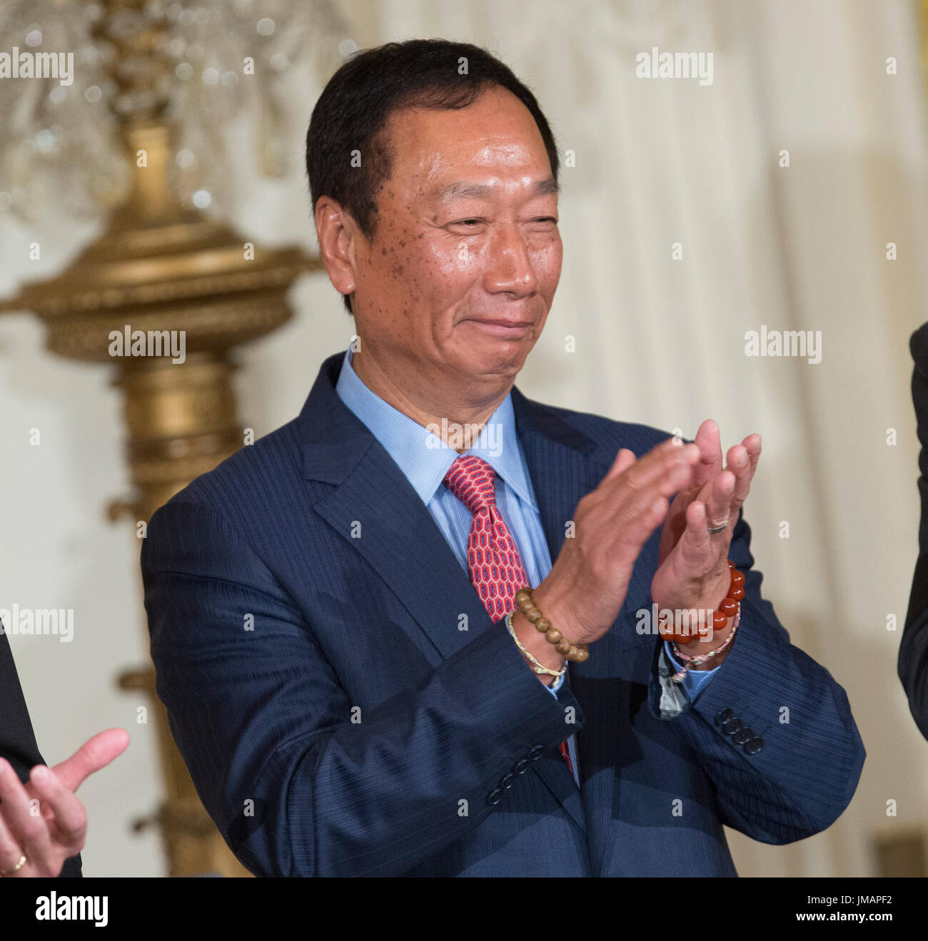 Foxconn CEO Terry Gou applauds during the announcement of the creation ...