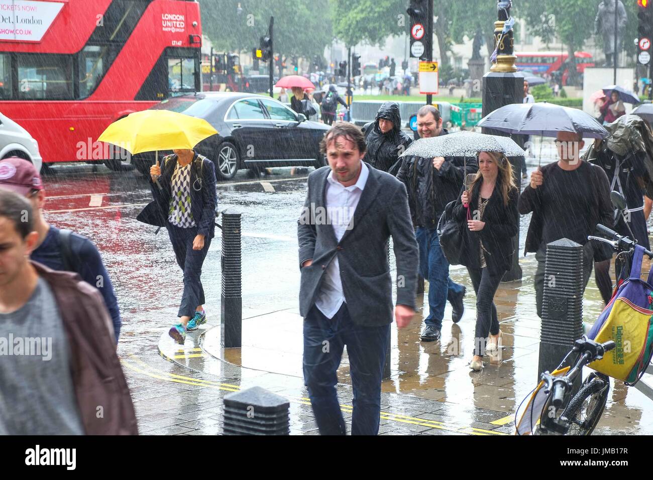 London, UK. 27th July, 2017. Heavy rain shower in Parliament Square ...
