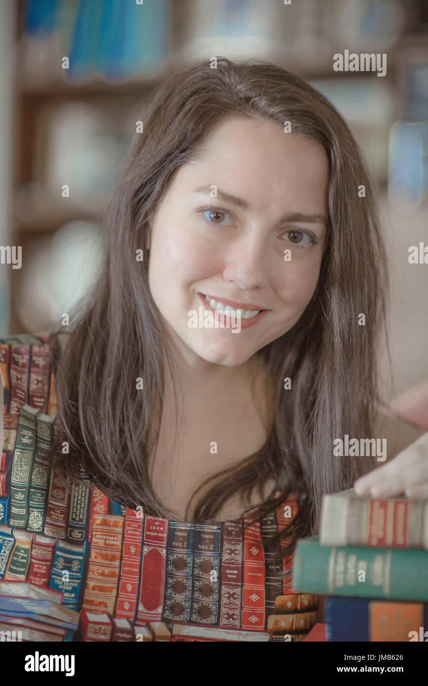 Woman with books in a dress with books on it Stock Photo - Alamy