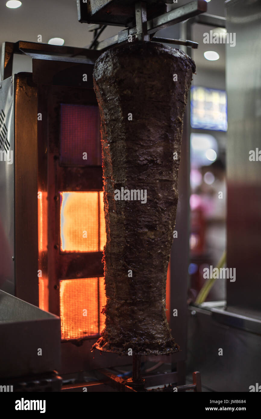strung meat, which is being prepared for cooking against metal wall ...