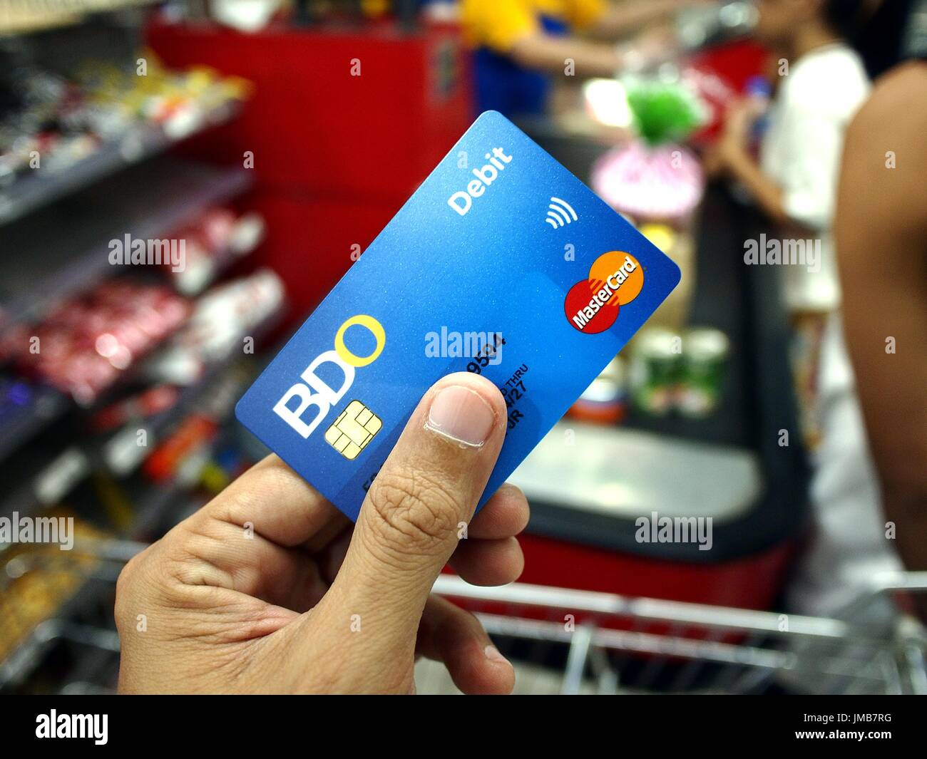 ANTIPOLO CITY, PHILIPPINES - JULY 17, 2017: A customer uses BDO debit ...