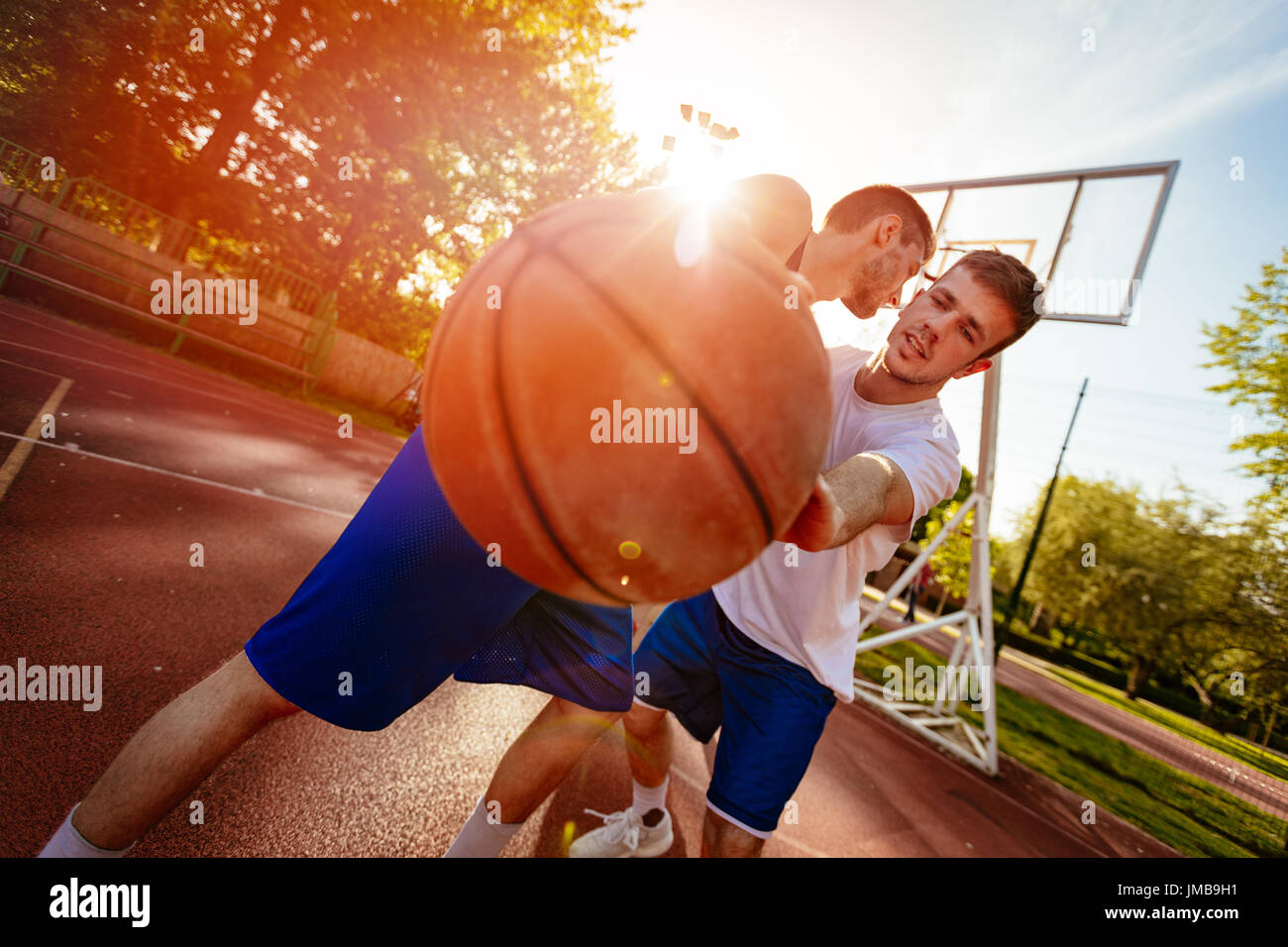 Two street basketball players playing one on one. They are making a ...