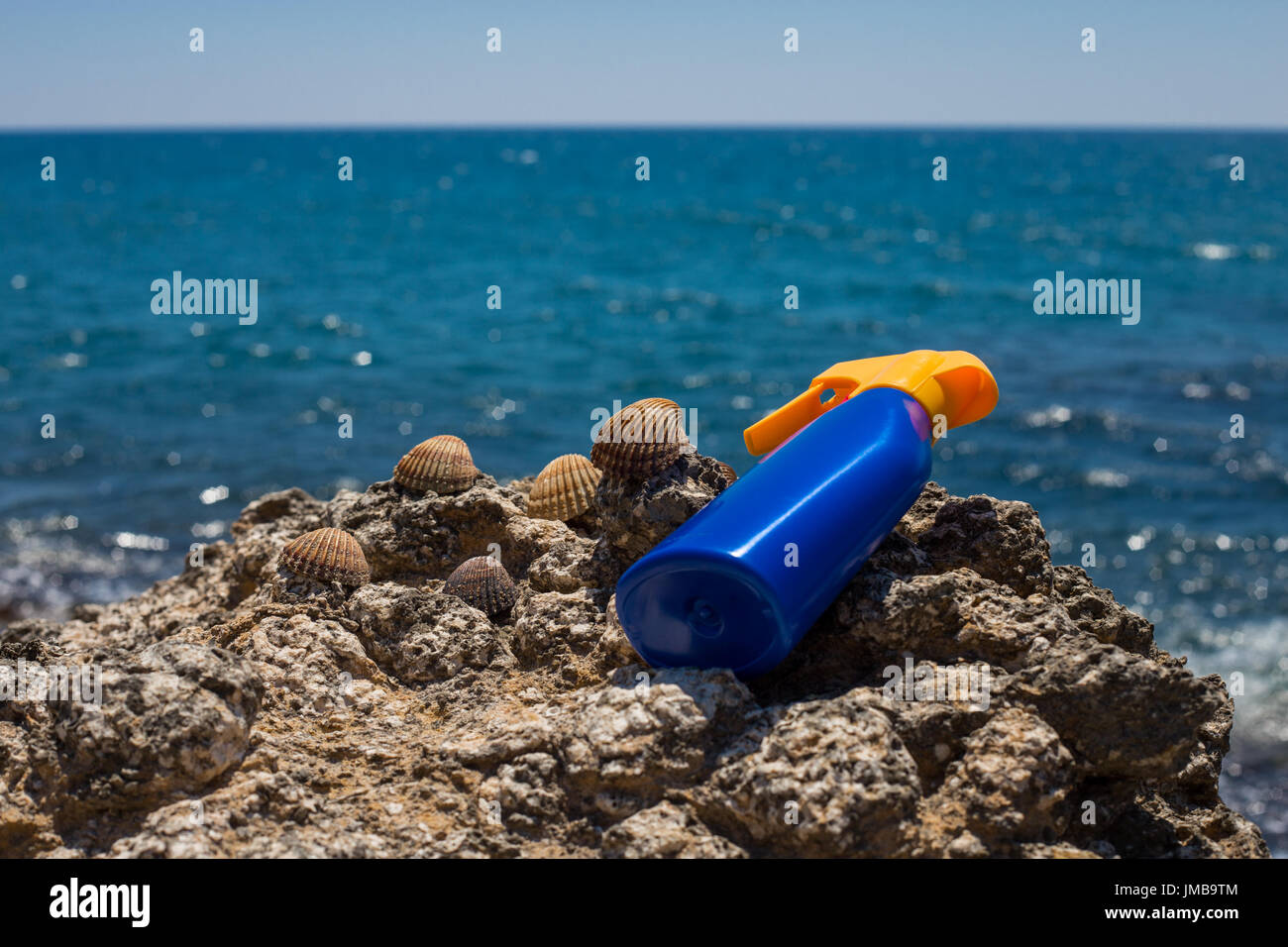 Sun cream sunscreen closeup laying on the beach rocks with dreamy sea ...