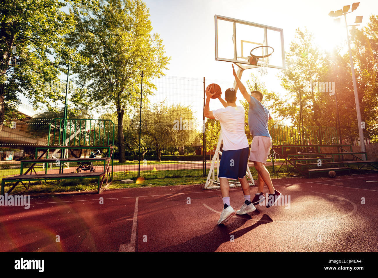 Two street basketball players having training outdoor. They are making ...