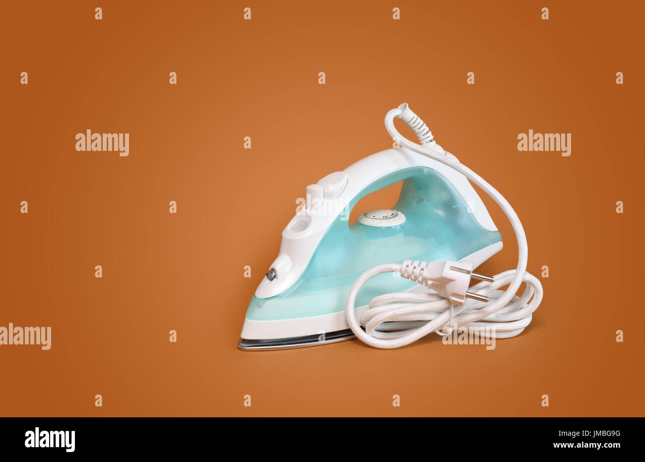 New modern electric iron with cable on nice brown background Stock ...