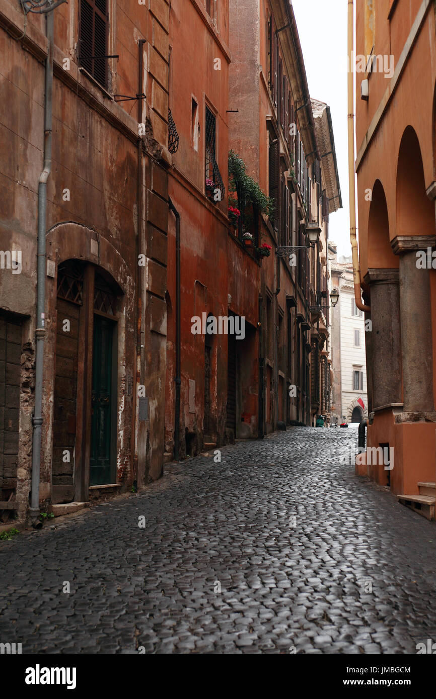 Nice narrow street with old buildings and stone paving. Rome, Italy ...