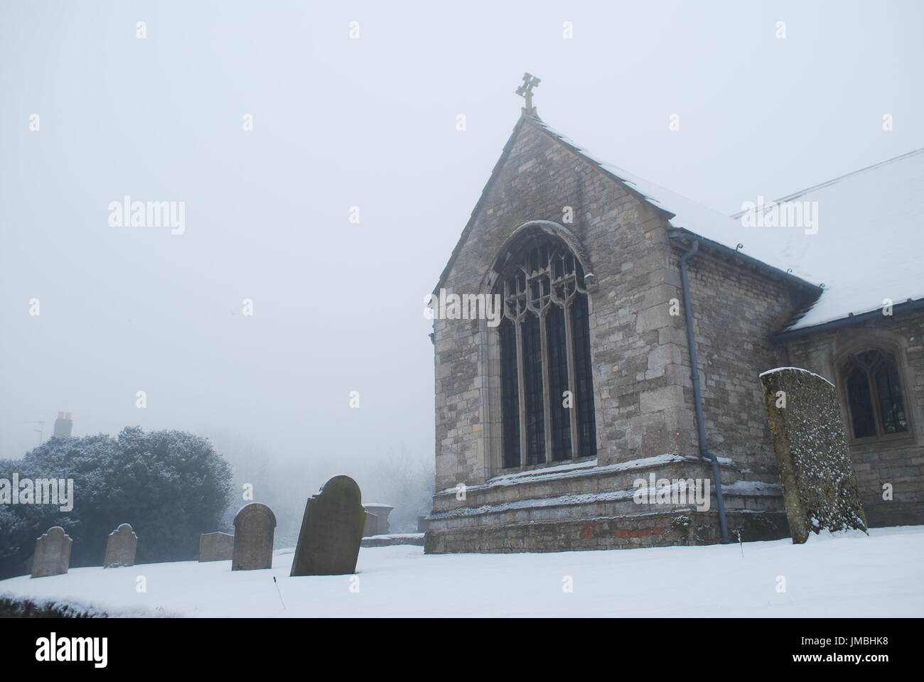 Snow covered church in mist Stock Photo - Alamy