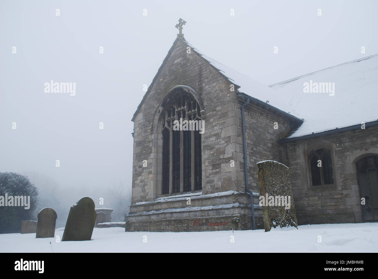 Snow covered church in mist Stock Photo - Alamy