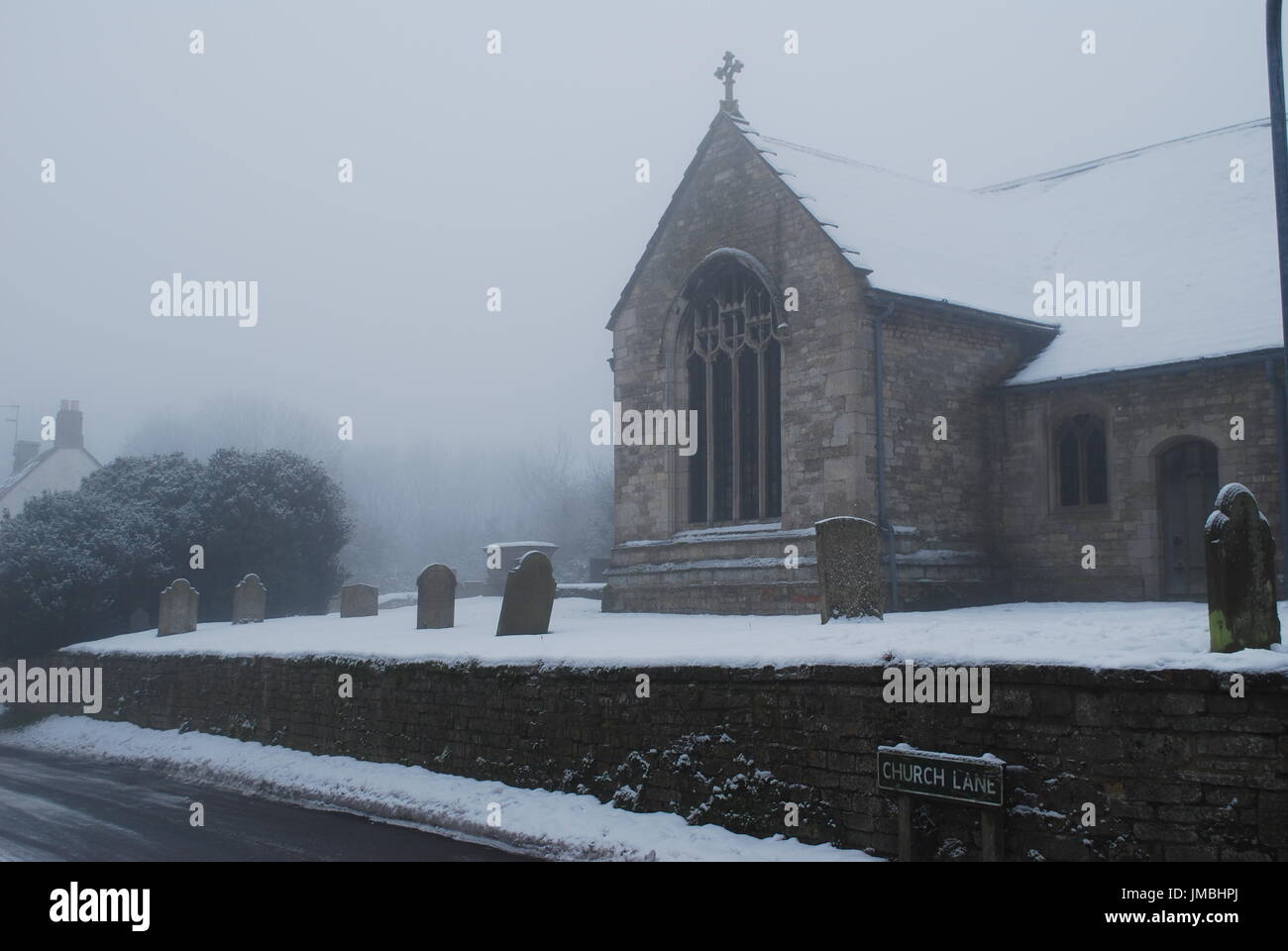 Snow covered church in mist Stock Photo - Alamy
