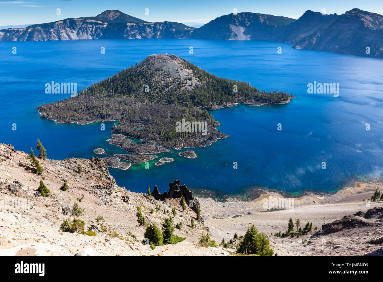 The volcanic cone of Wizard Island with trees growing in the rock and ...