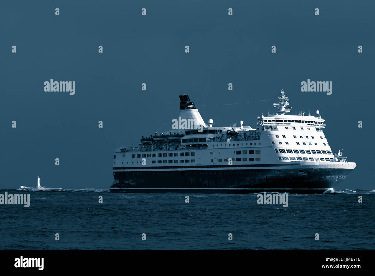 Passenger ship sailing from the sea in the morning. Toned dark blue ...