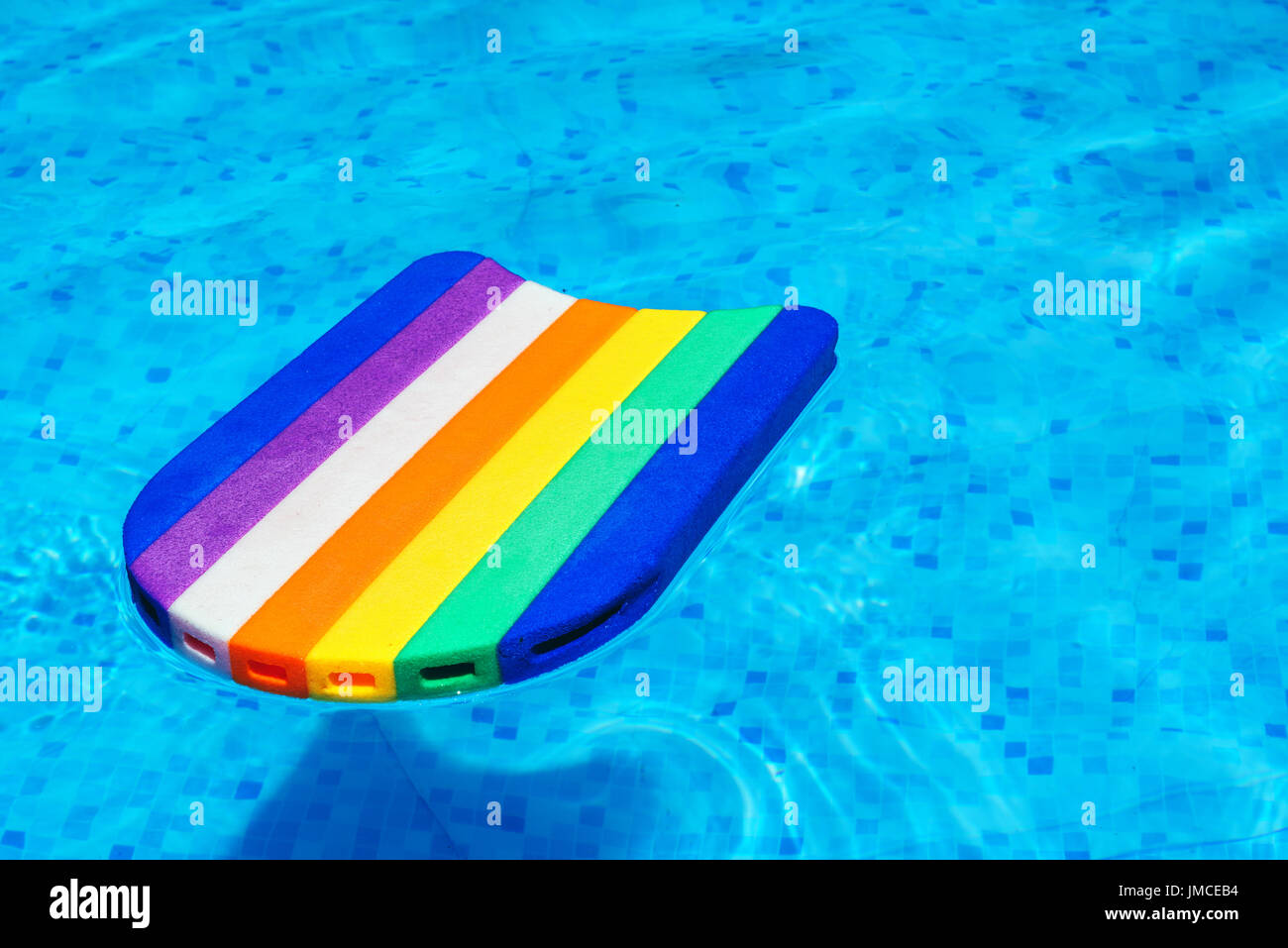 Rainbow pattern styrofoam swimming board or baseboard floating in ...