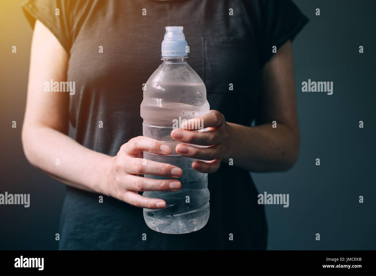 Woman with bottle of fresh drinking water for refreshment and ...