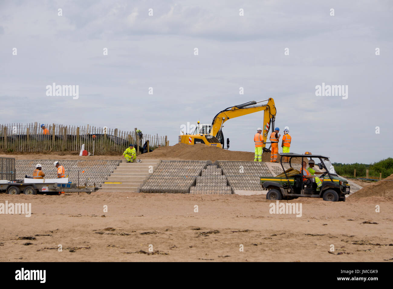 Workers moving sand with diggers and building access to the beach at ...