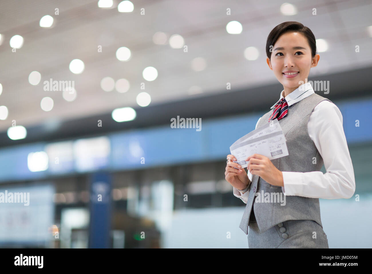 Smiling Chinese airline stewardess with airplane tickets Stock Photo ...