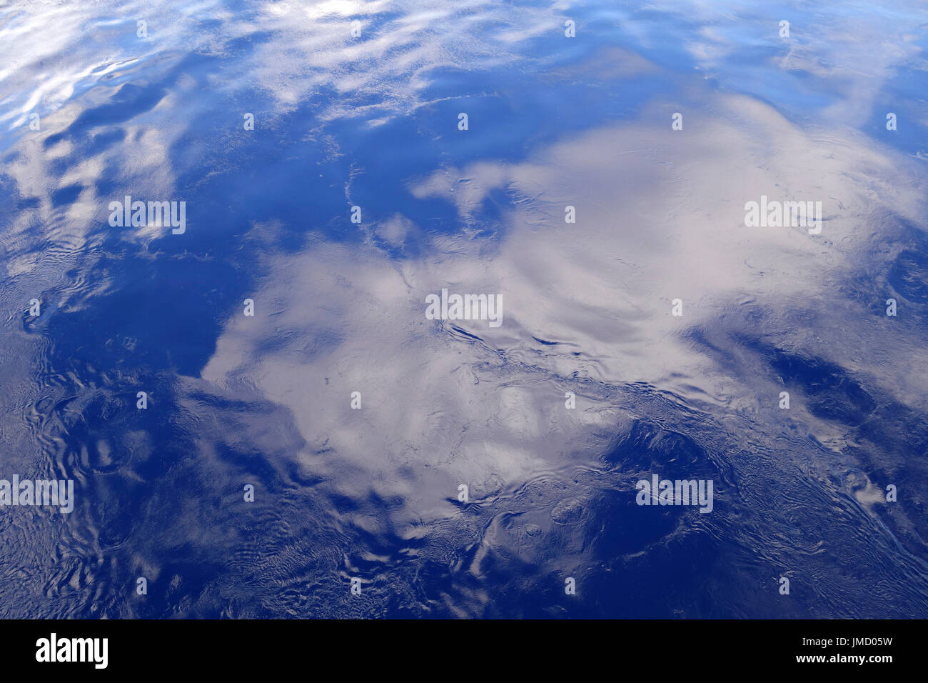 Smooth ocean surface reflecting clouds and sky with ripples Stock Photo ...