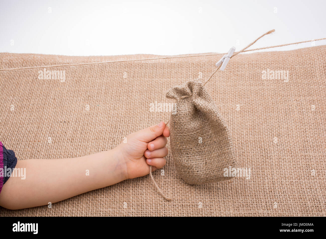 Hand holding an empty little sack made of linen Stock Photo - Alamy