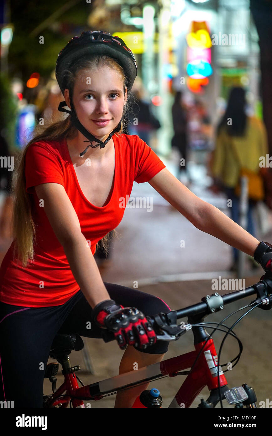 City night bicycle ride. Girls wearing bicycle helmet. Nightlife and ...