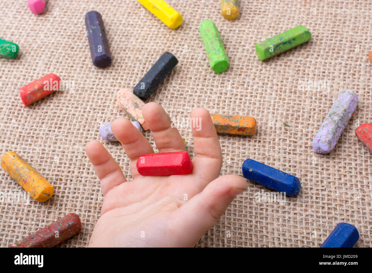Used color crayons and a toddlers hand holding one Stock Photo - Alamy